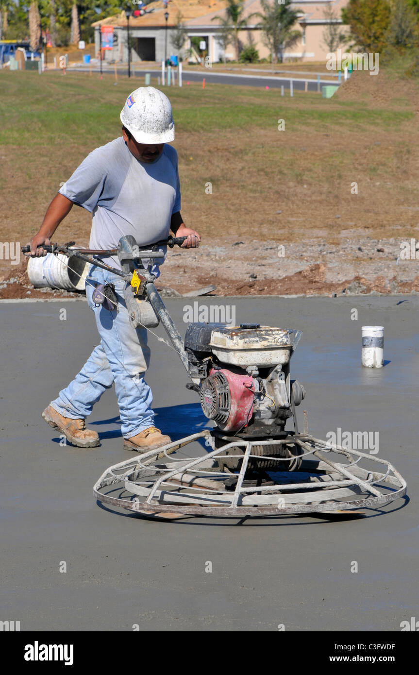 Latino hispanic Mason workers work to finish cement floor on new home ...
