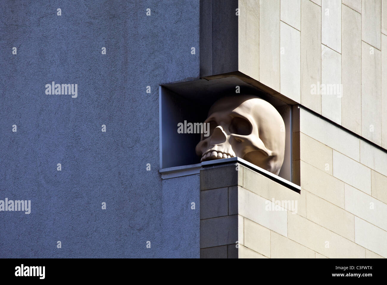 A large human skull statue built into the corner of a building on ...