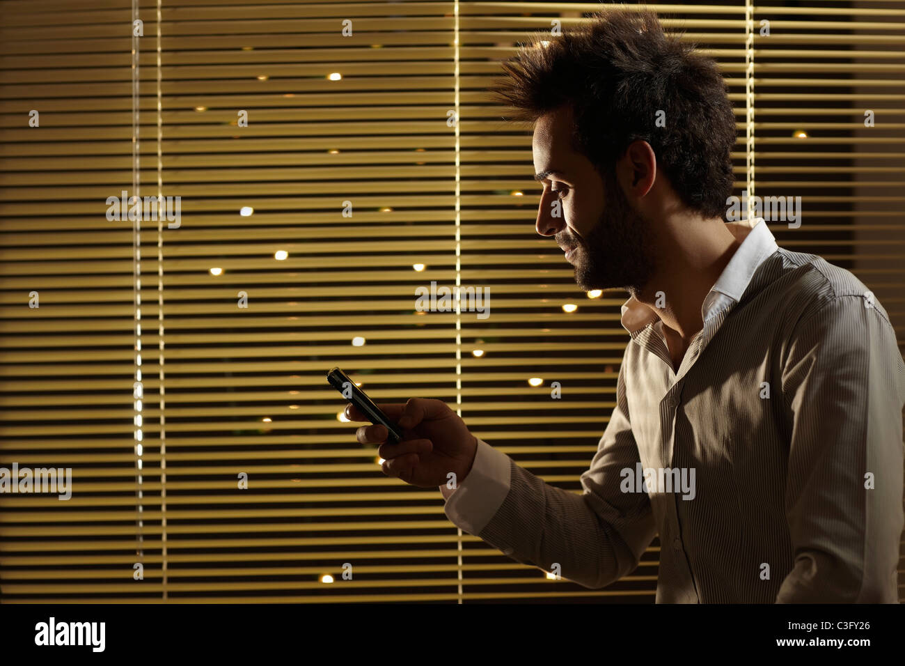 Caucasian man text messaging on cell phone at night Stock Photo - Alamy