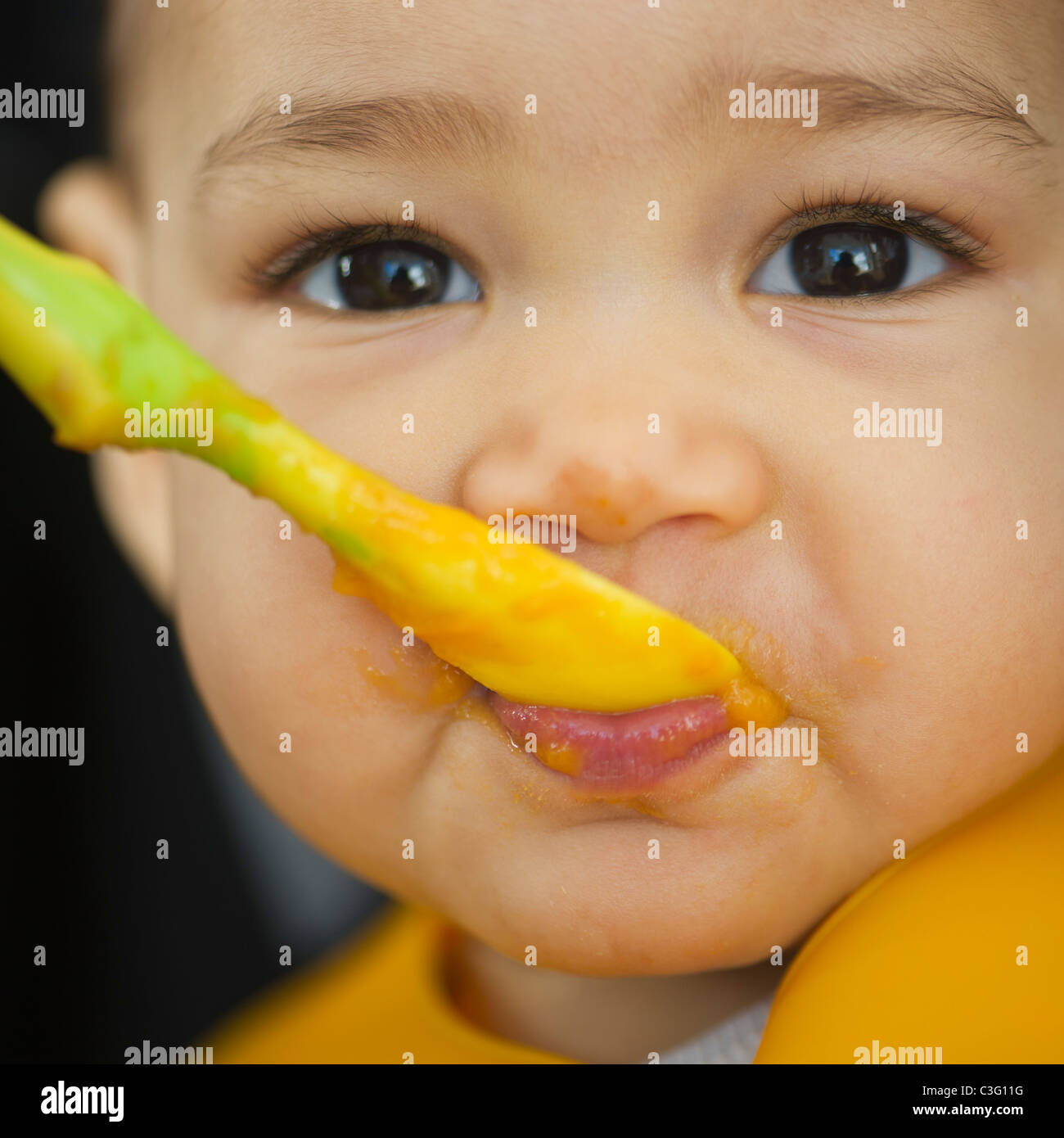 Mixed race baby eating from spoon Stock Photo - Alamy
