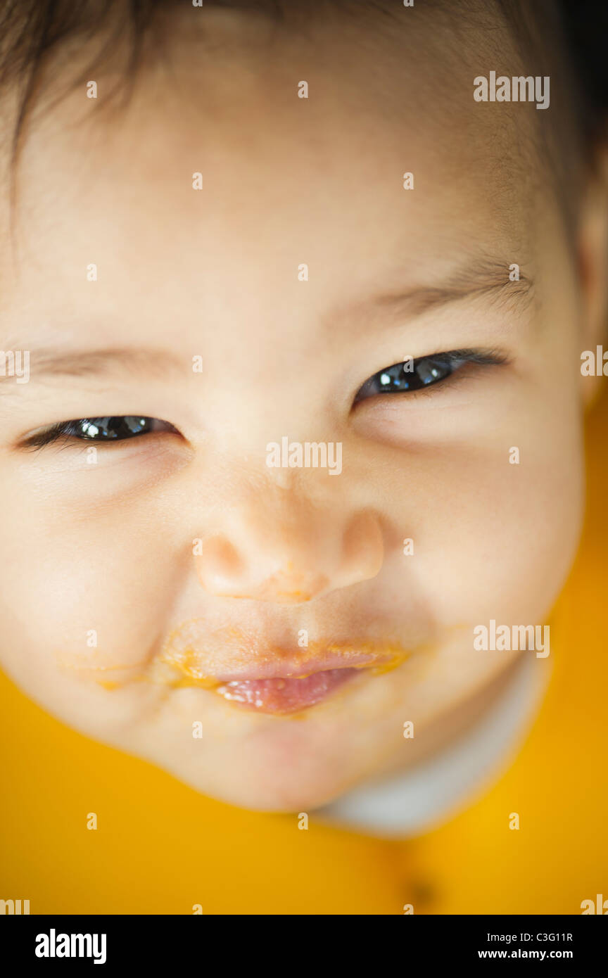Grinning mixed race baby with messy face Stock Photo - Alamy