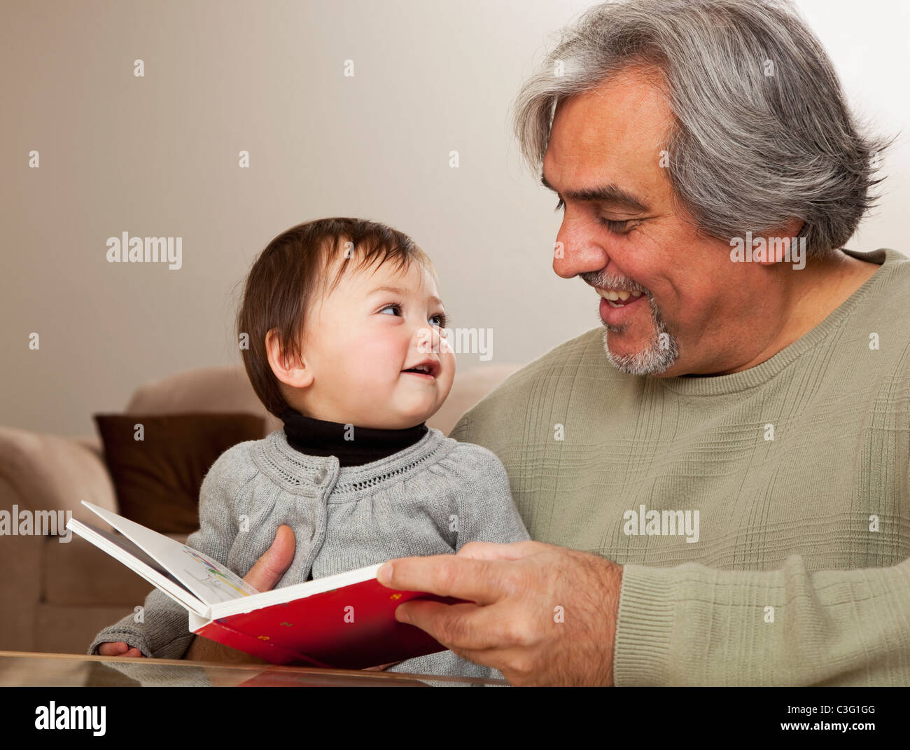 Grandfather reading book to granddaughter Stock Photo - Alamy