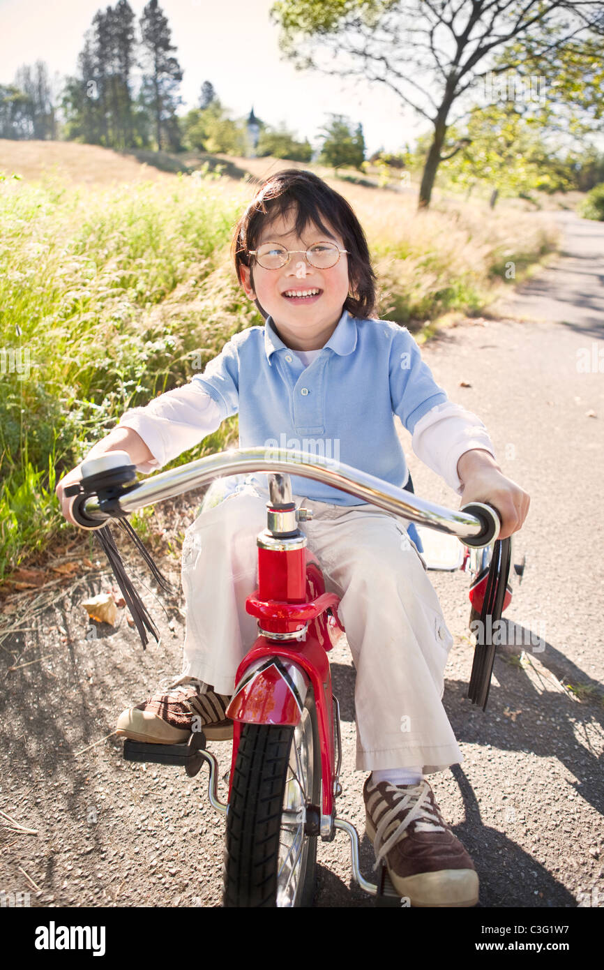 Chinese boy riding tricycle on sidewalk Stock Photo - Alamy