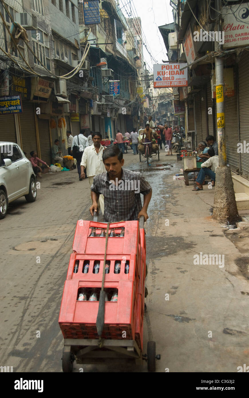 Man pushing crates of soft drink bottles on a cart, Chandni Chowk ...