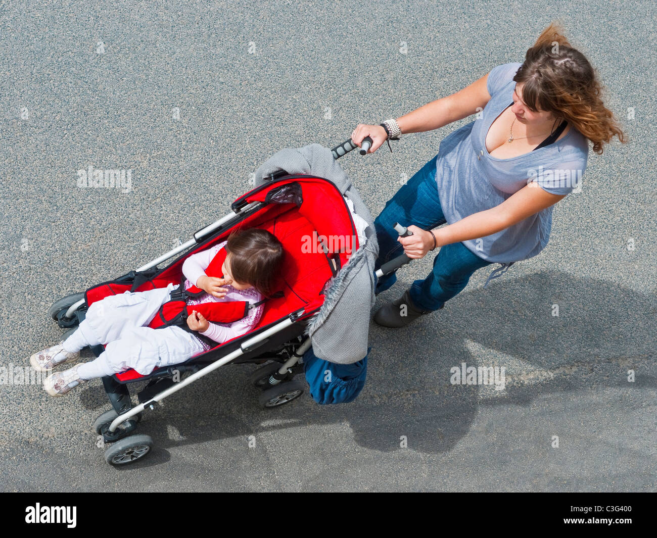 Young woman pushing child in buggy - France Stock Photo - Alamy