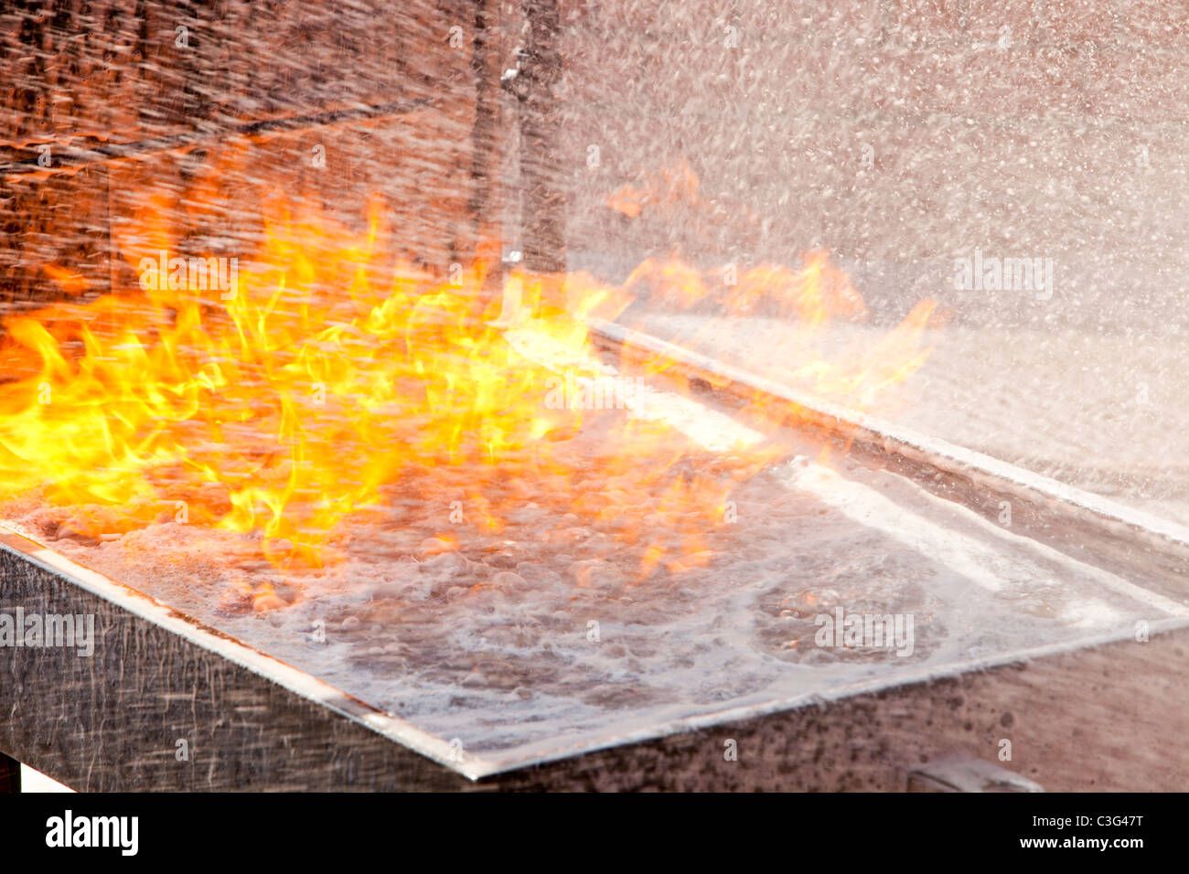 Fighting a fire with a foam fire extinguisher Stock Photo - Alamy