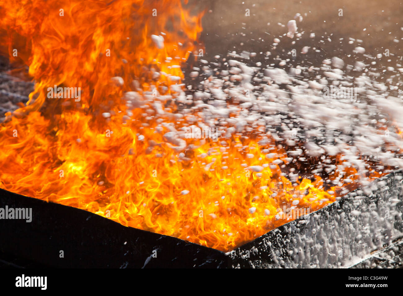 Fighting a fire with a foam fire extinguisher Stock Photo - Alamy