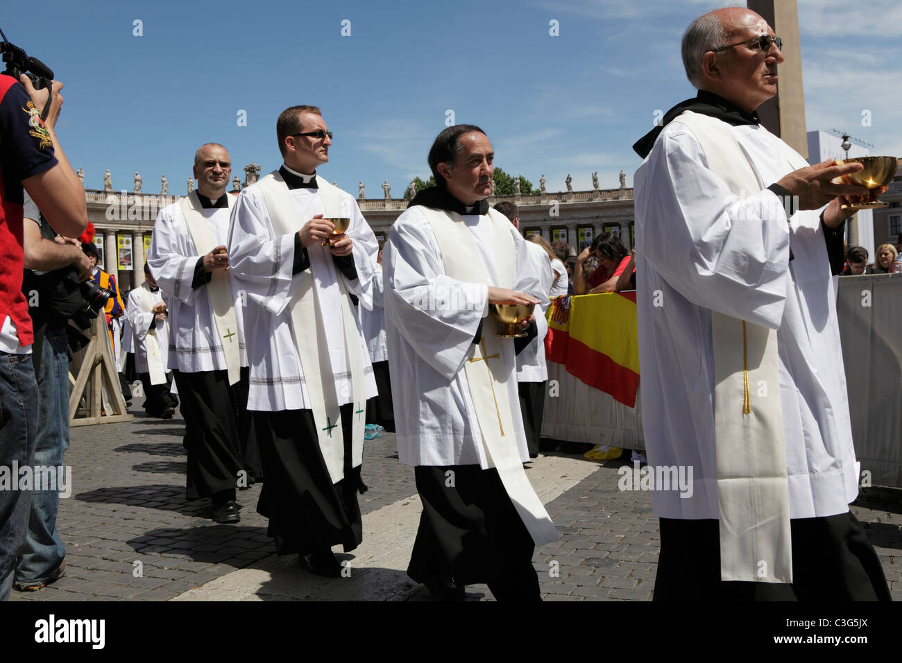 Priests giving out holy communion to faithful in Saint Peter's square ...