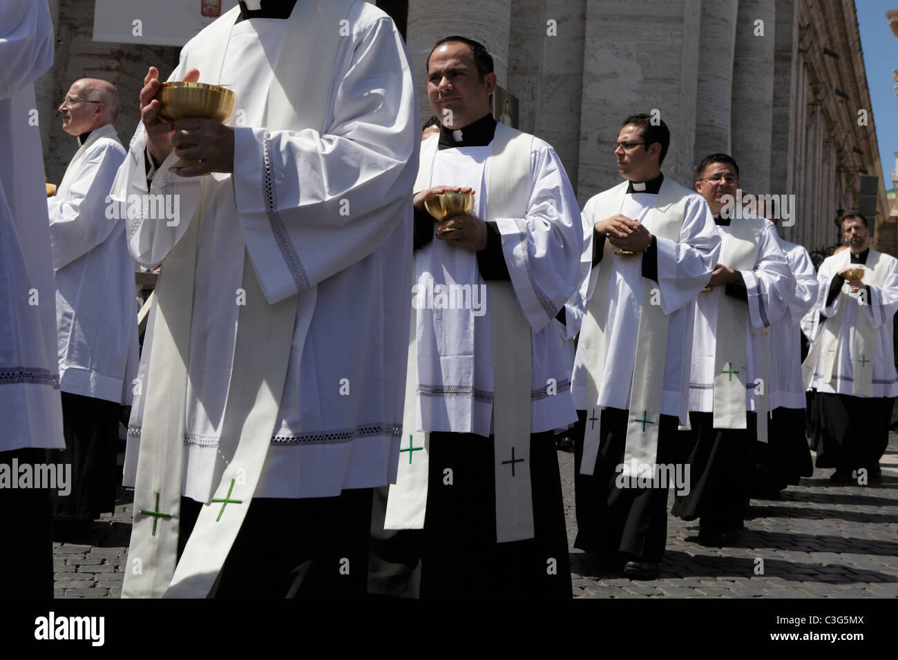 Priests giving out holy communion to faithful in Saint Peter's square ...