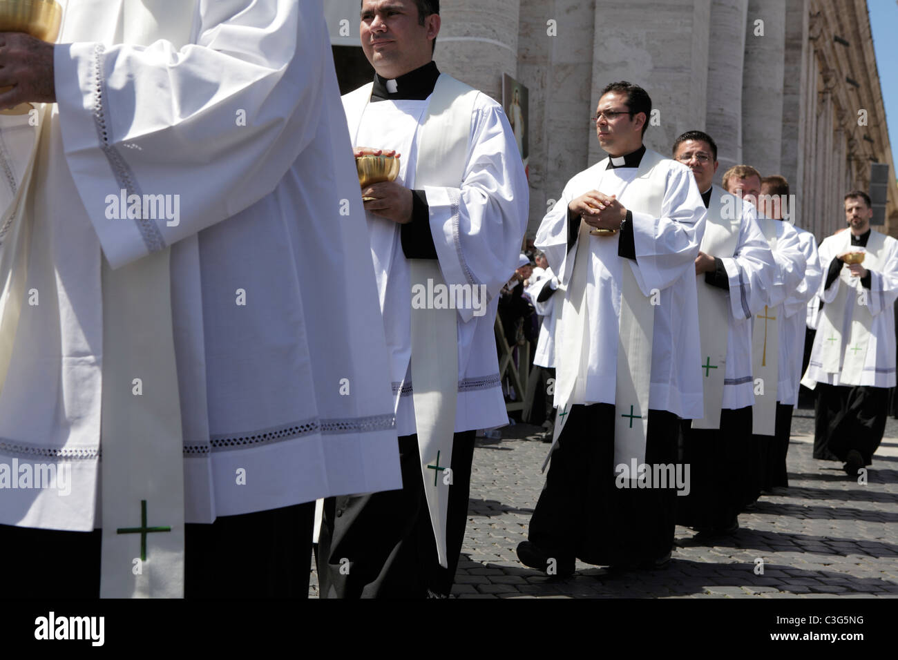 Priests giving out holy communion to faithful in Saint Peter's square ...