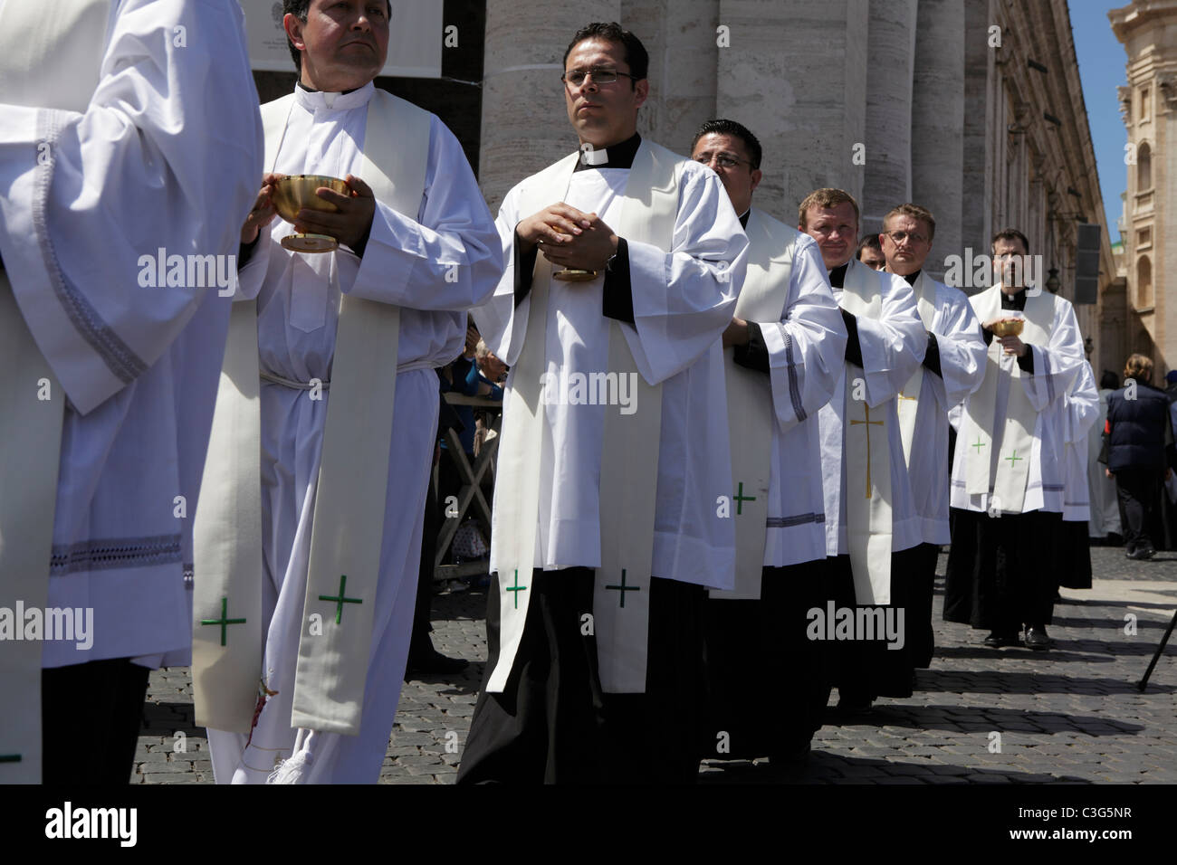 Priests giving out holy communion to faithful in Saint Peter's square ...