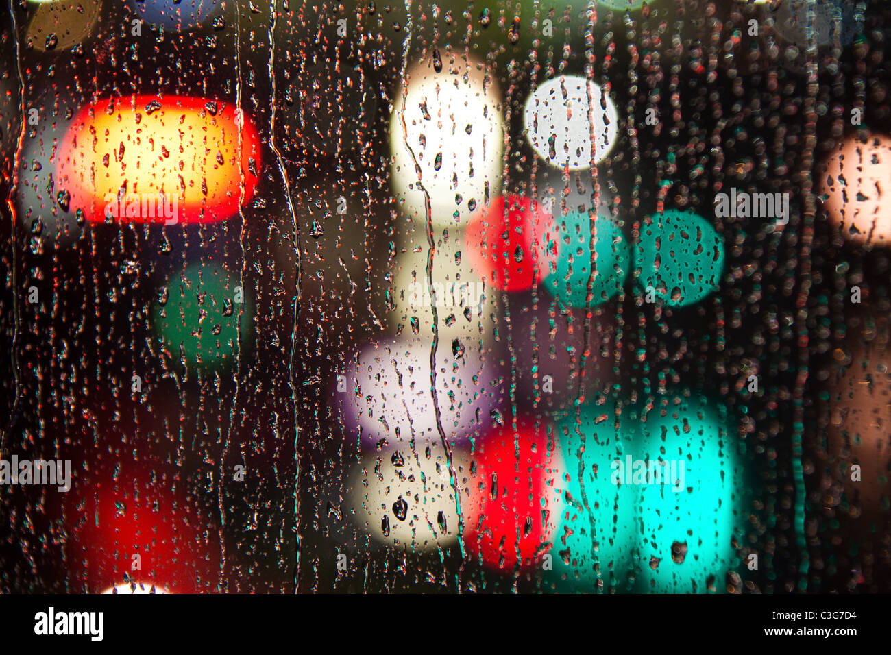 Lights of cars, traffic lights and businesses as seen through a rain ...