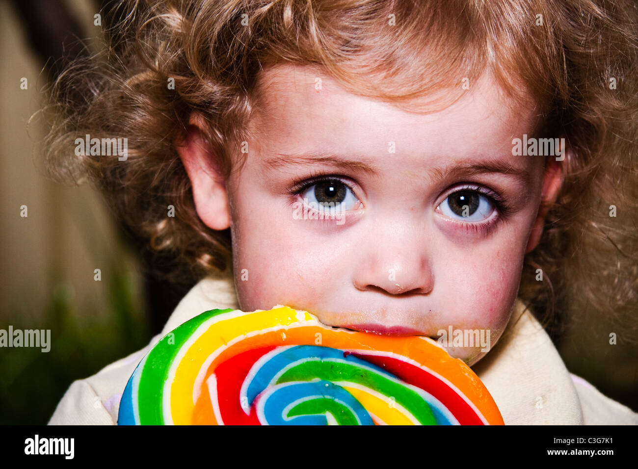 Portrait of a young girl eating candy Stock Photo - Alamy