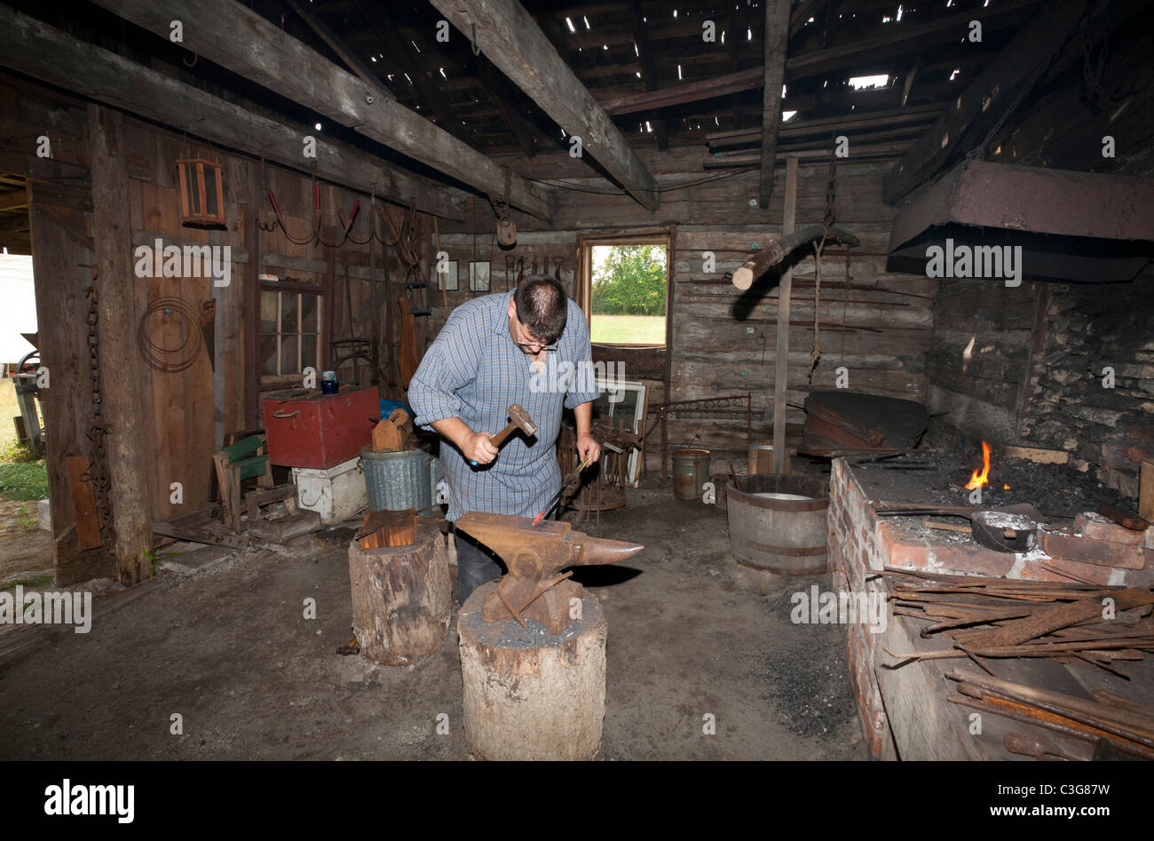 Blacksmith hammering out a piece of iron Stock Photo - Alamy