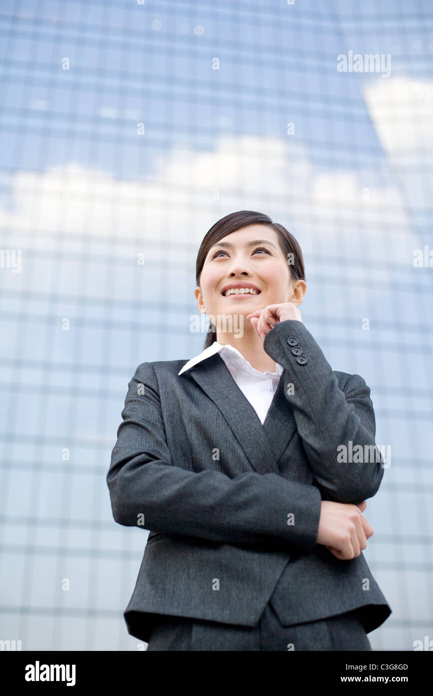 Young businesswoman standing in front of a tall building Stock Photo ...