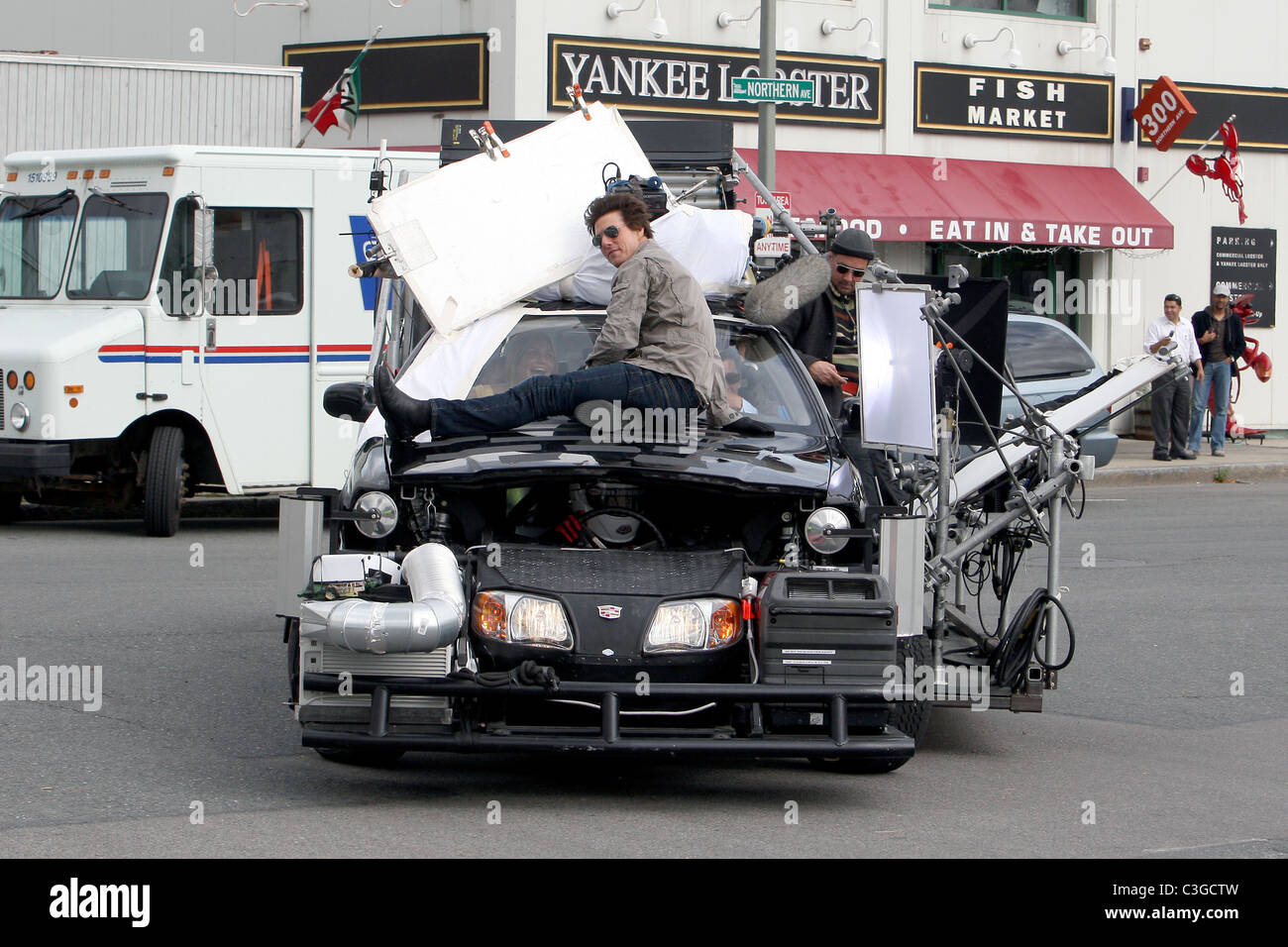 Tom Cruise filming a stunt scene on top of a car while on the set of ...