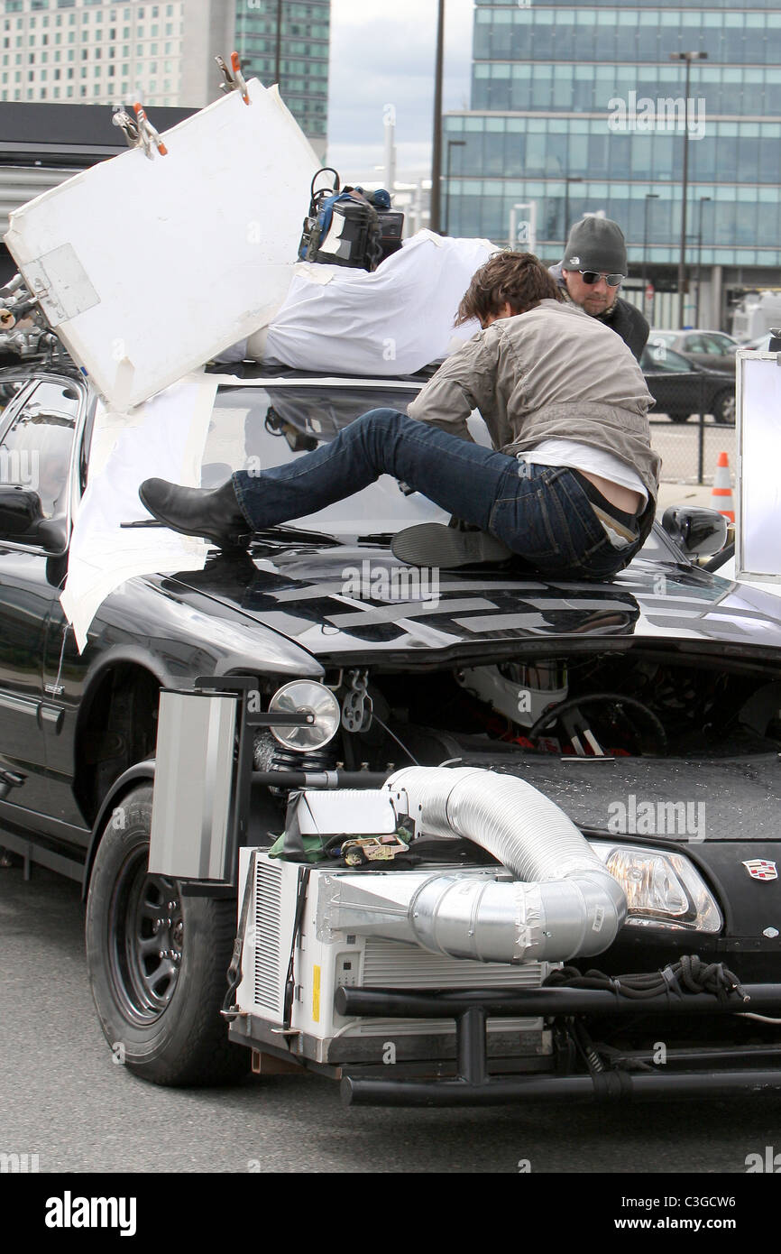 Tom Cruise filming a stunt scene on top of a car while on the set of ...