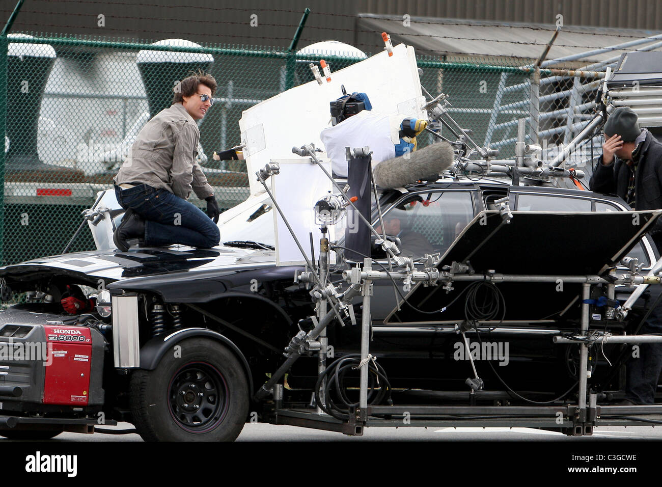Tom Cruise filming a stunt scene on top of a car while on the set of ...