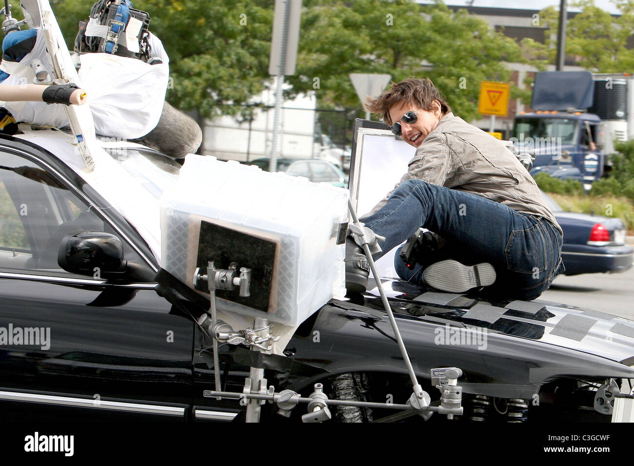 Tom Cruise filming a stunt scene on top of a car while on the set of ...