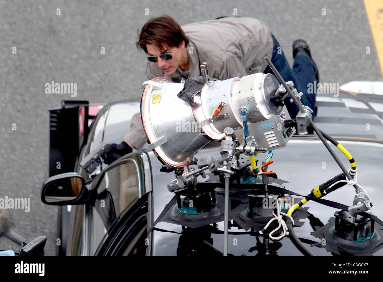 Tom Cruise filming a stunt scene on top of a car while on the set of ...