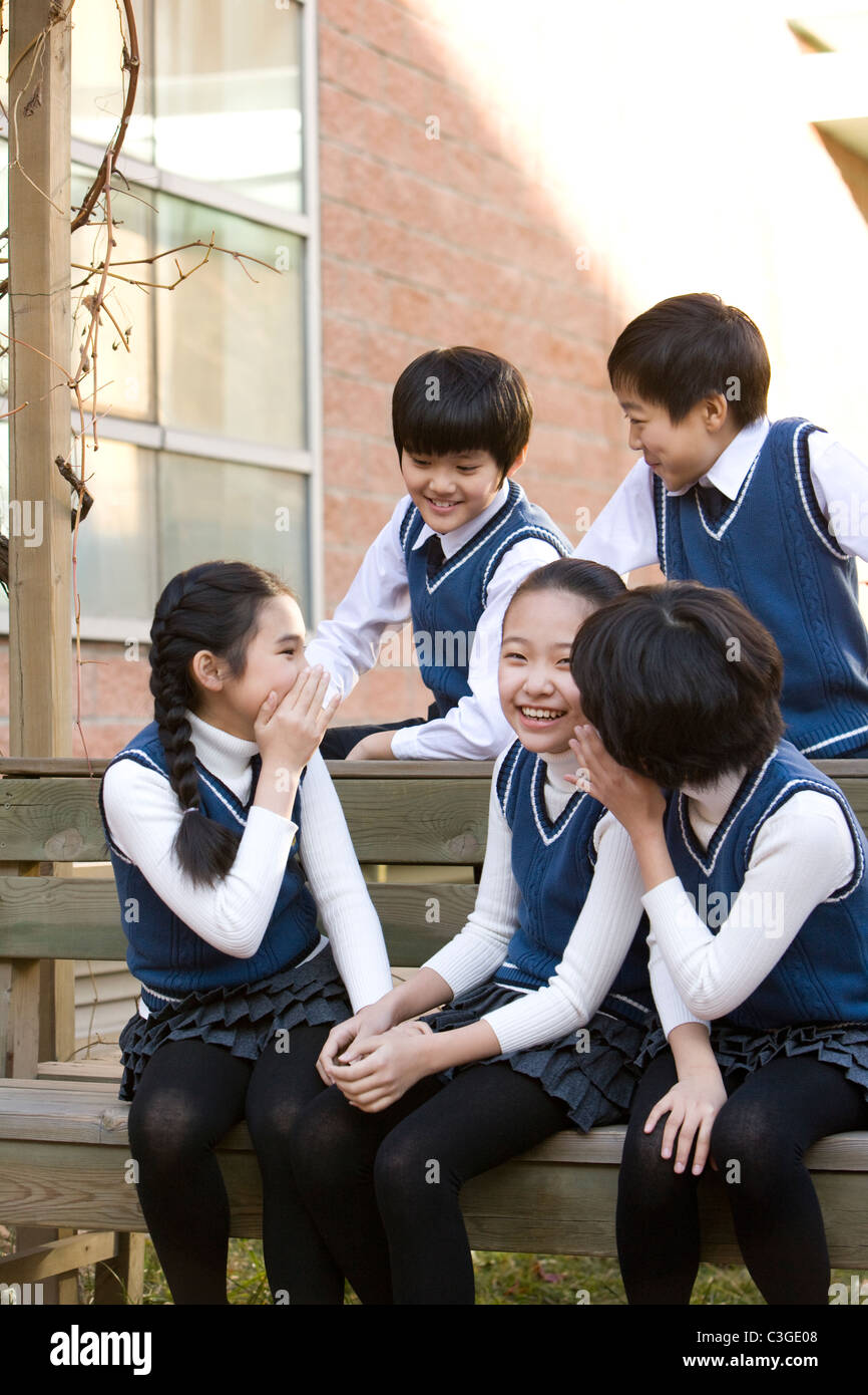Five classmates talking on a school bench Stock Photo - Alamy