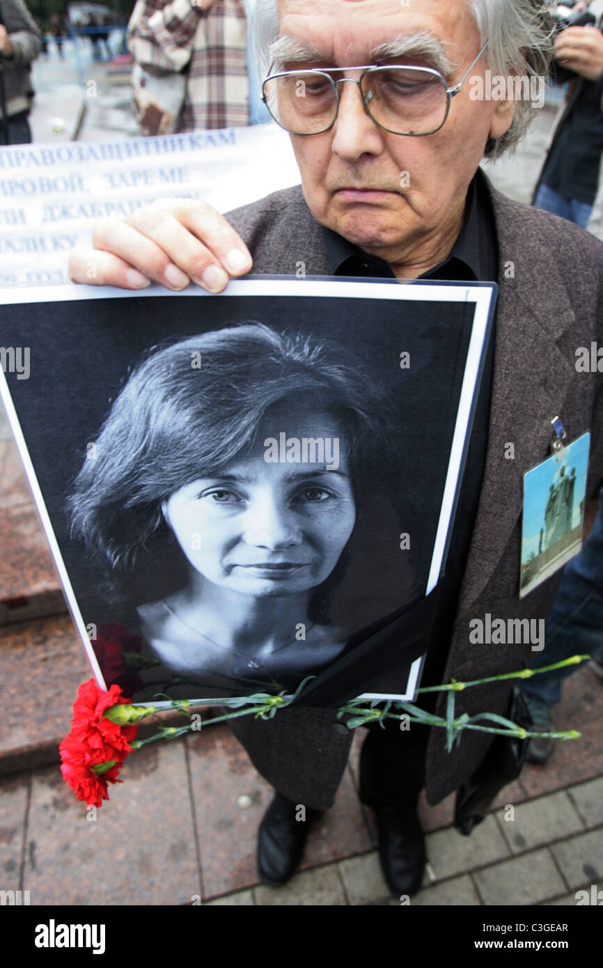 A man holding a portrait of Natalia Estemirova Memorial Human Rights ...