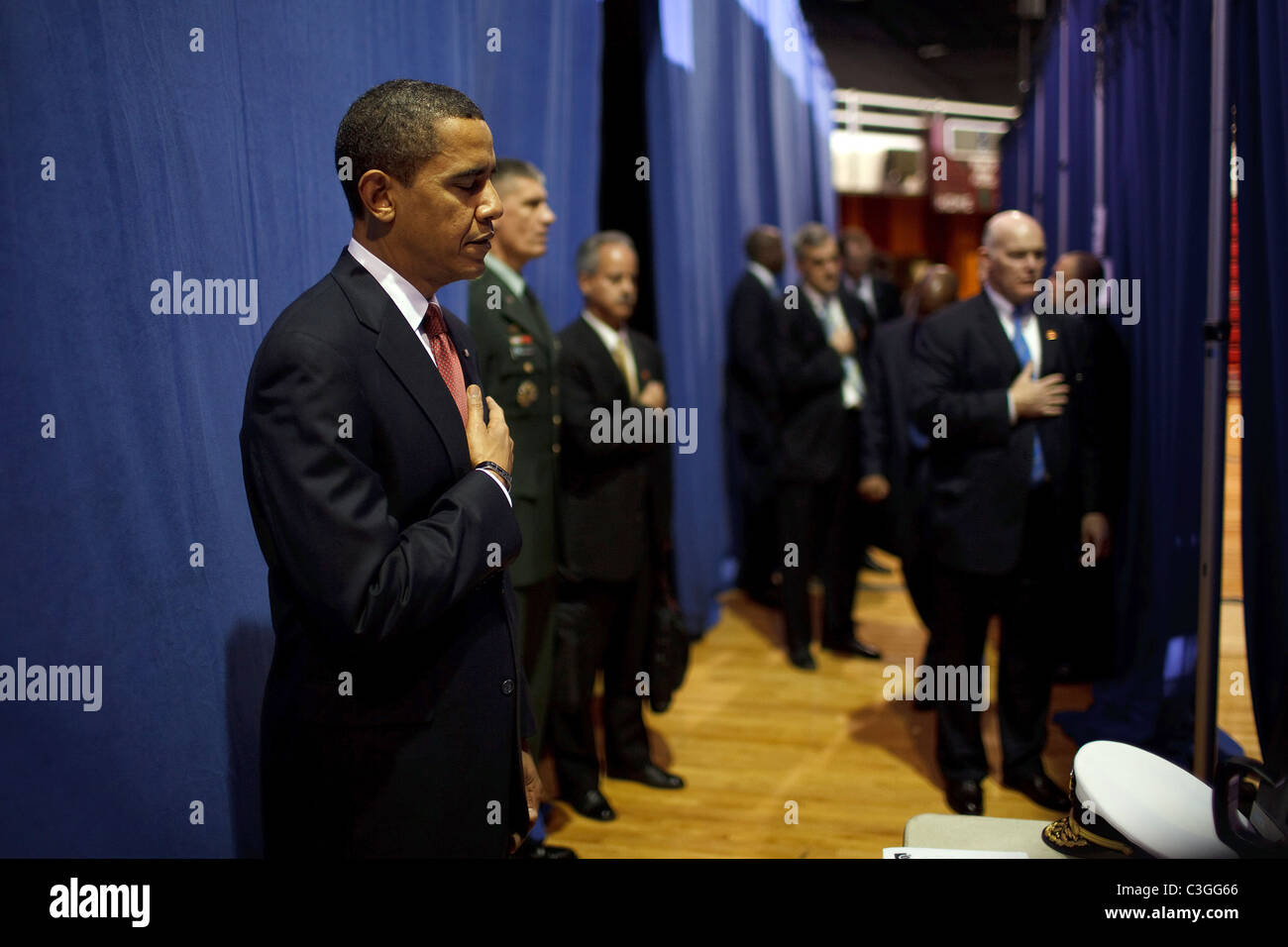 President Barack Obama places his hand on his heart as the national ...