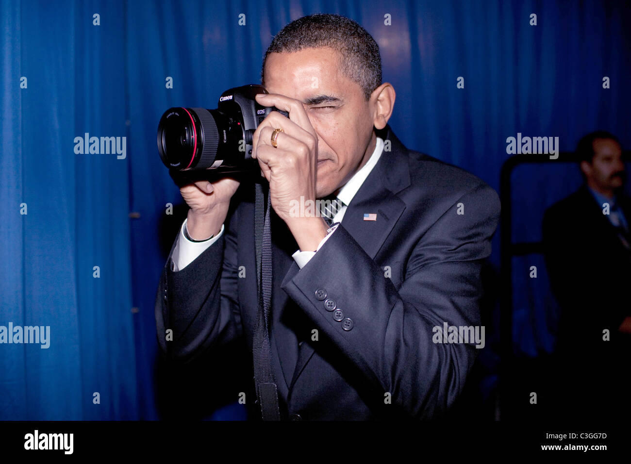 President Barack Obama takes aim with a photographer's camera backstage ...