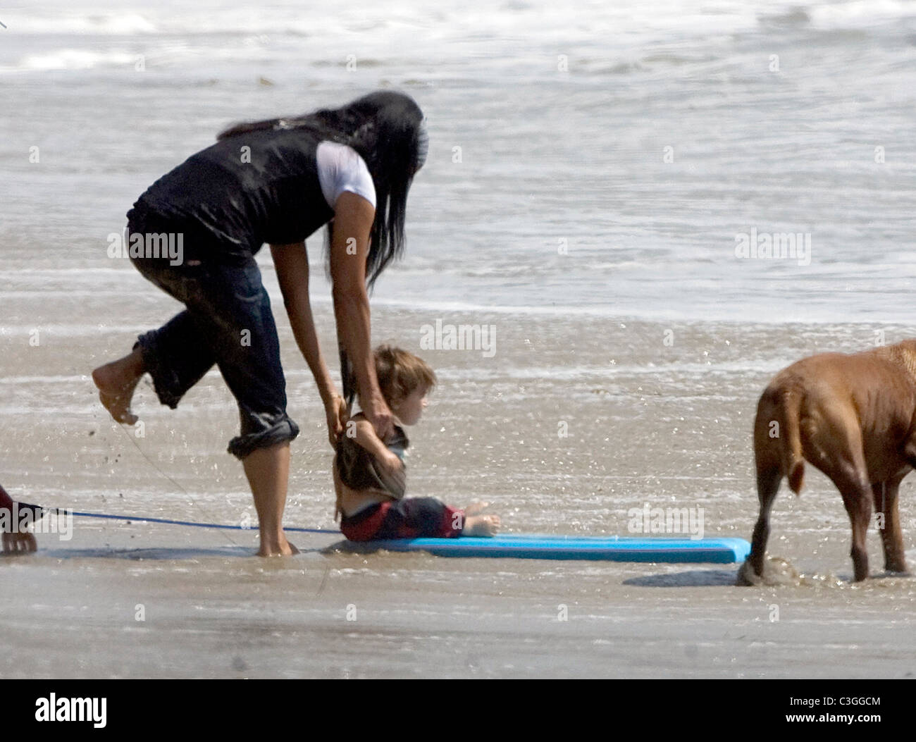 Levi McConaughey plays with his nanny and his dogs on a beach in Malibu ...