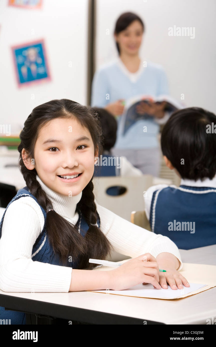 Young student sitting at her desk in the classroom Stock Photo - Alamy