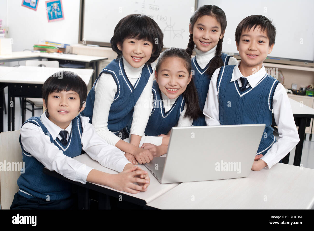 Students gathered around a computer in the classroom Stock Photo - Alamy