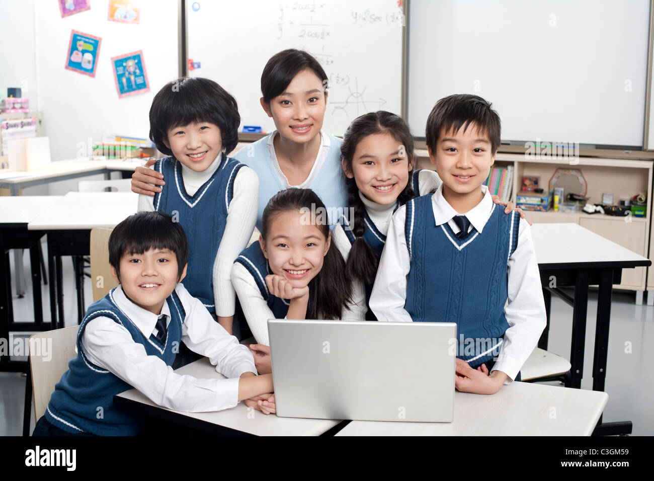 Students and teacher gathered around a computer in the classroom Stock ...