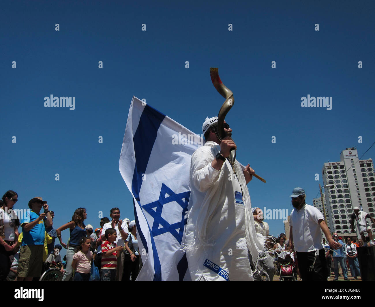 A religious Jewish man dance while waving Israeli flag at the seacoast ...