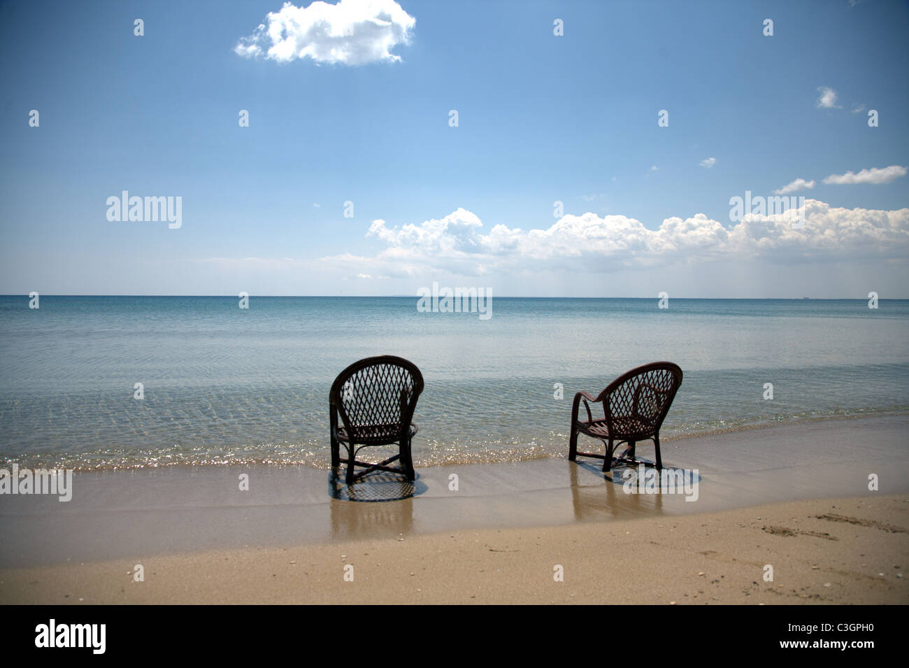 two chairs in the shallow water looking out to sea Stock Photo - Alamy