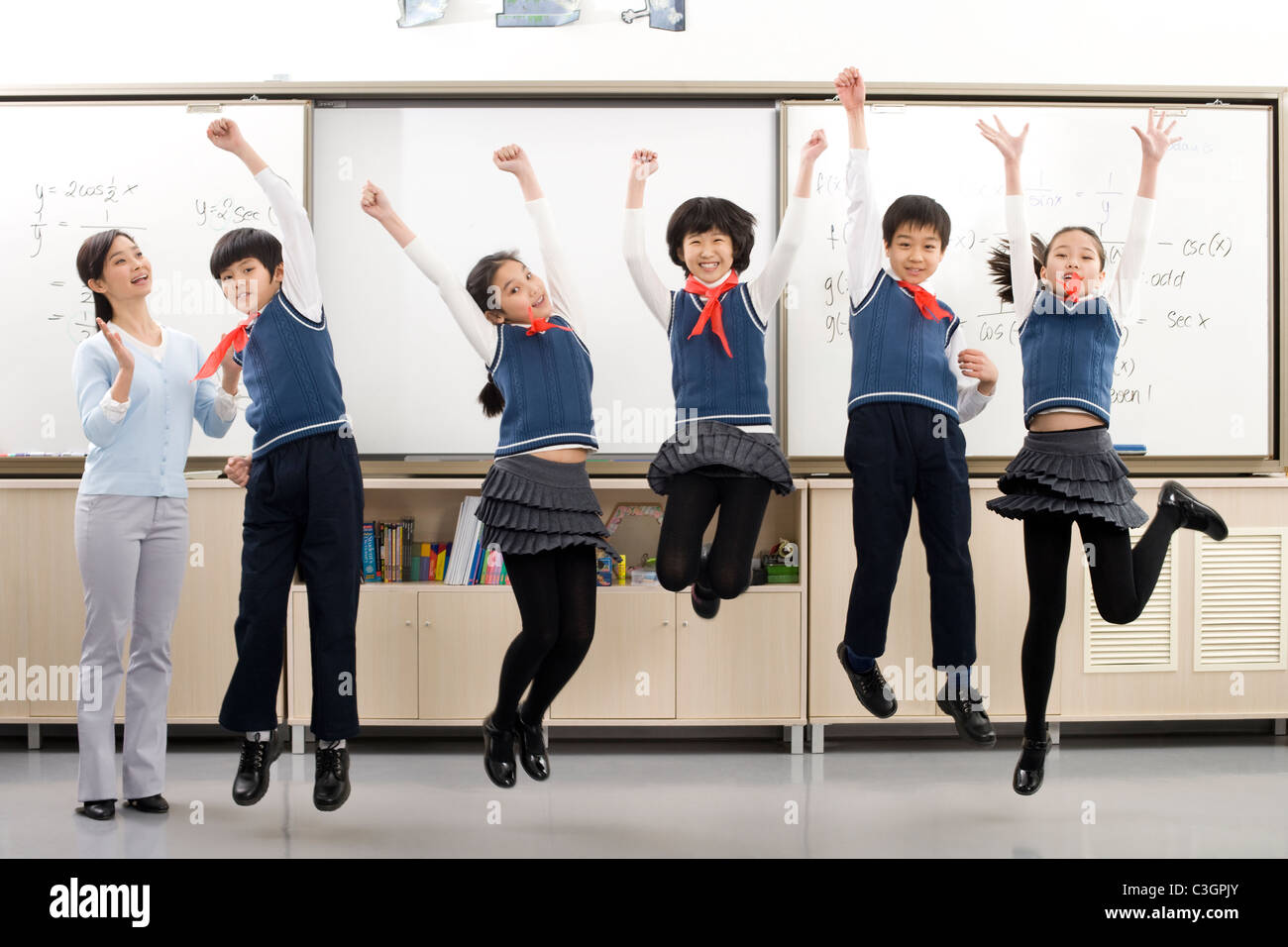 Young students jumping in front of whiteboard Stock Photo - Alamy