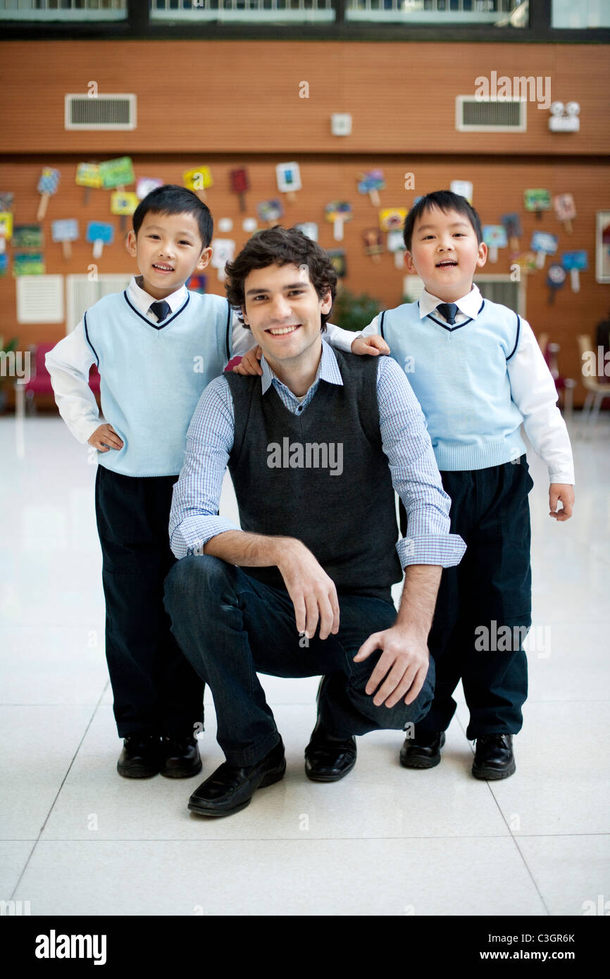 Teacher and two young students posing in campus Stock Photo - Alamy