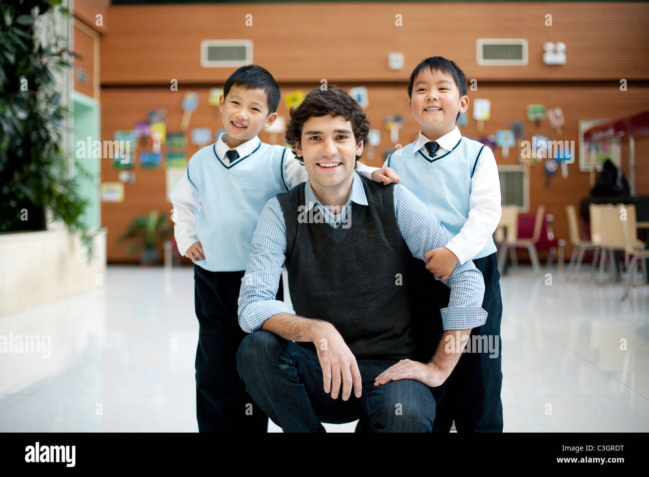 Teacher and two young students posing in campus Stock Photo - Alamy