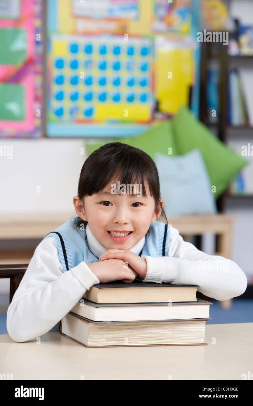 Young student holding books in classroom Stock Photo - Alamy