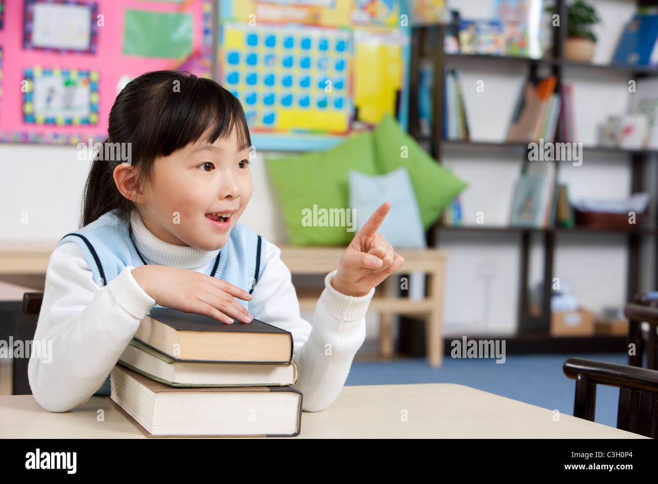 Young student holding books in classroom Stock Photo - Alamy