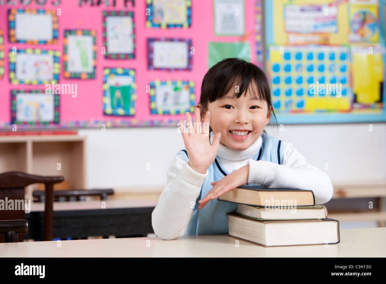 Young student holding books in classroom Stock Photo - Alamy