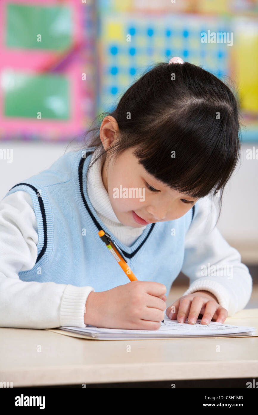 Young student writing in classroom Stock Photo - Alamy