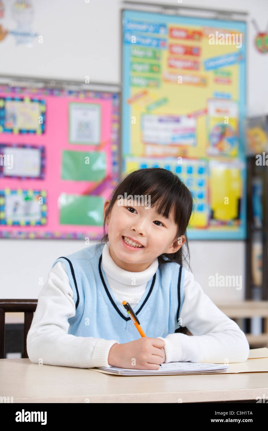Young student writing in classroom Stock Photo - Alamy