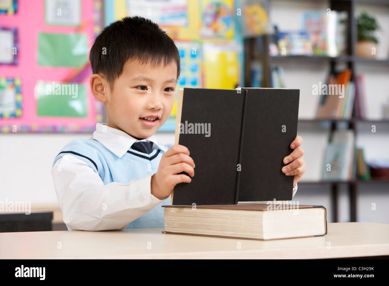Young student reading in classroom Stock Photo - Alamy