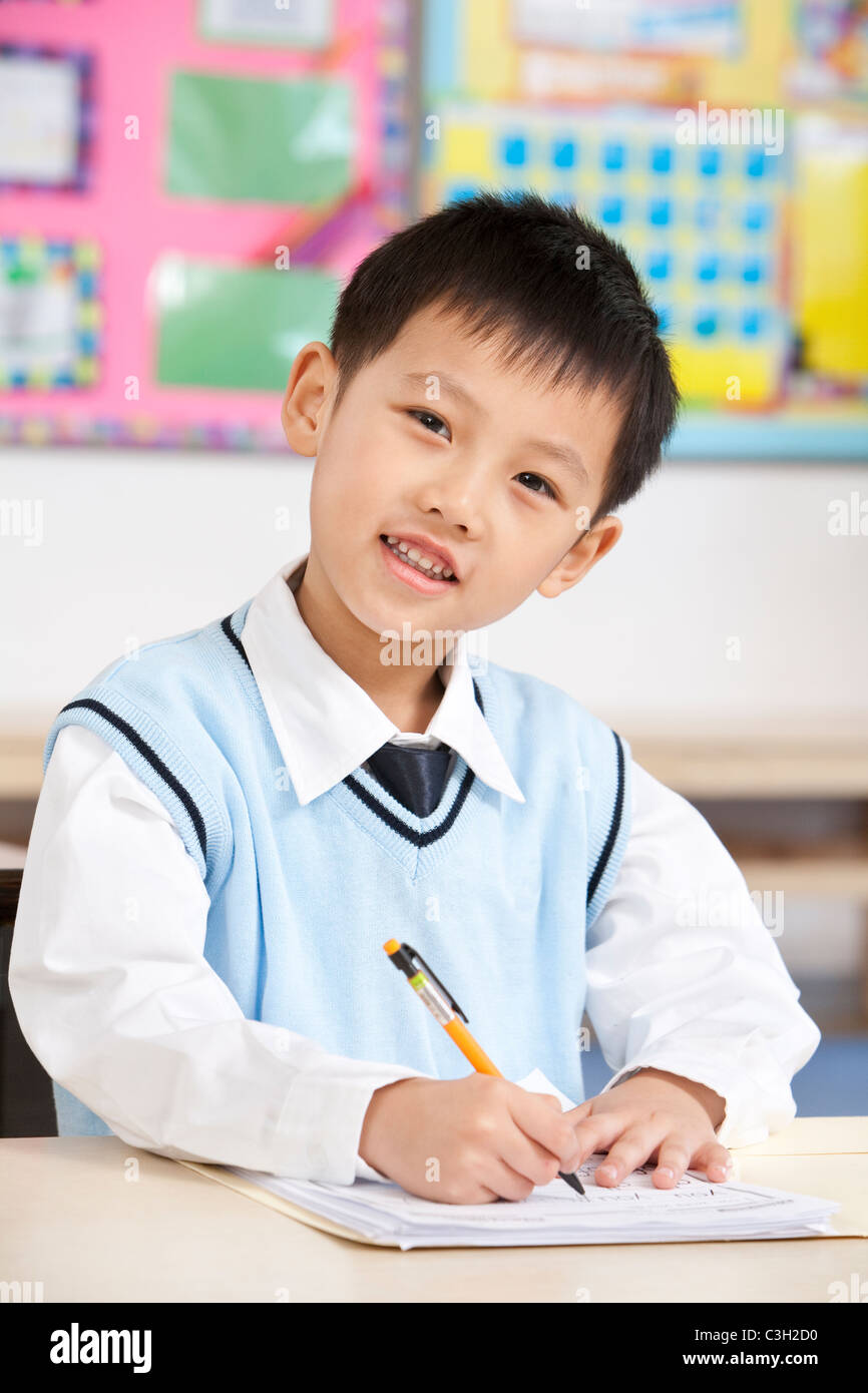 Young student writing in classroom Stock Photo - Alamy