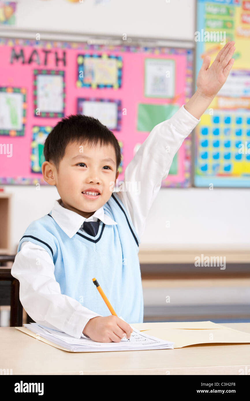 Young boy raising hand in classroom Stock Photo - Alamy Young boy raising hand in classroom Stock Photo - Alamy