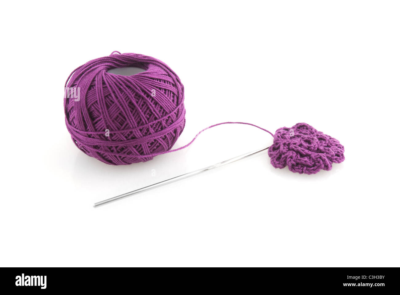 Purple spool and needle on a white background Stock Photo - Alamy