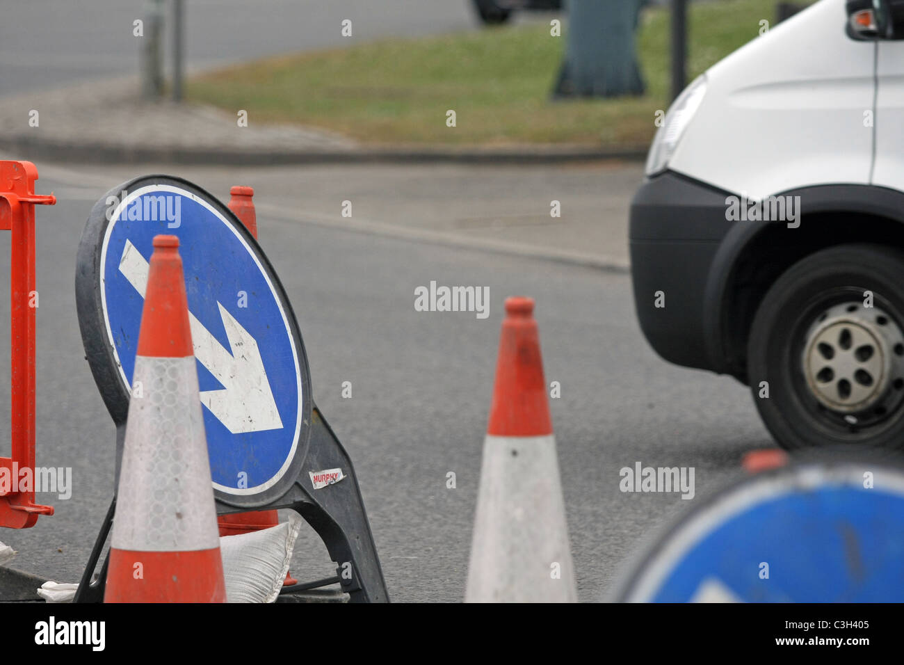 Part of a vehicle passing direction signs and cones in roadworks in ...