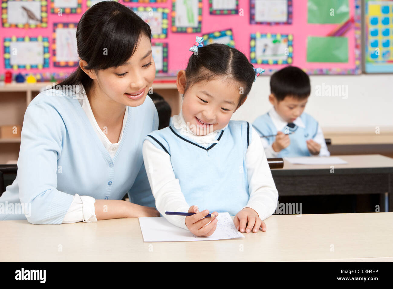 Teacher assisting student in class Stock Photo - Alamy