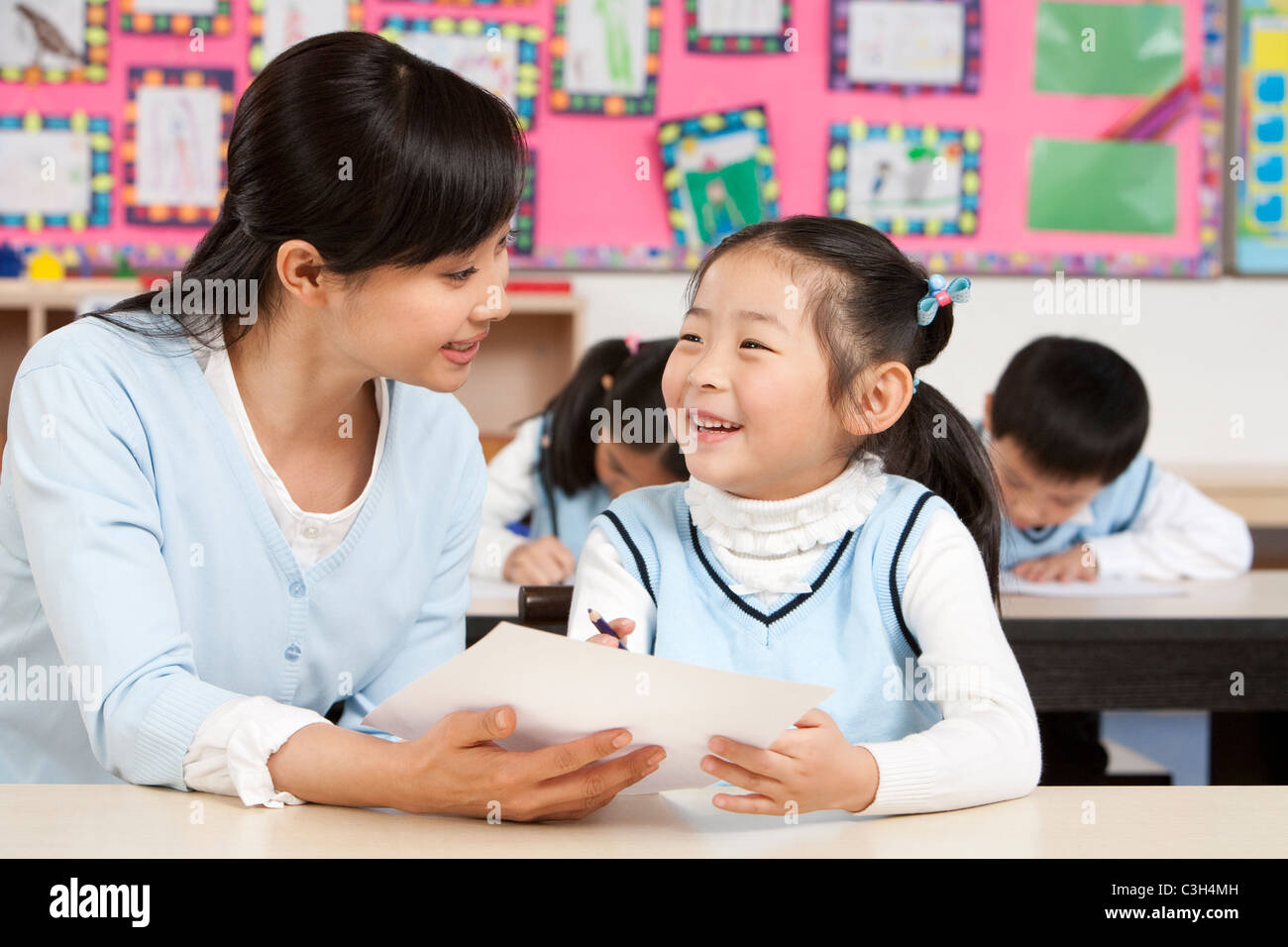 Teacher assisting student in class Stock Photo - Alamy