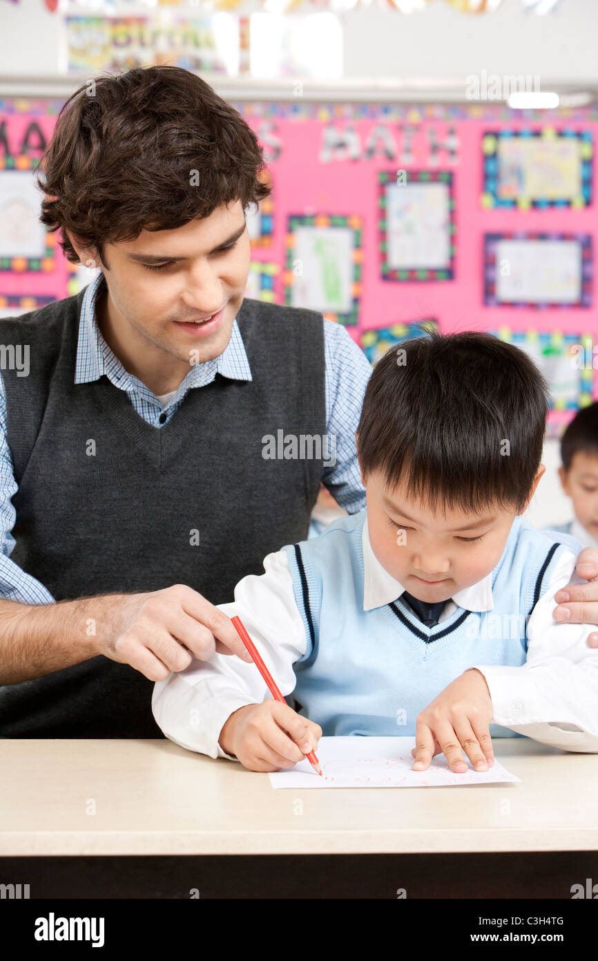 Teacher assisting student in class Stock Photo - Alamy